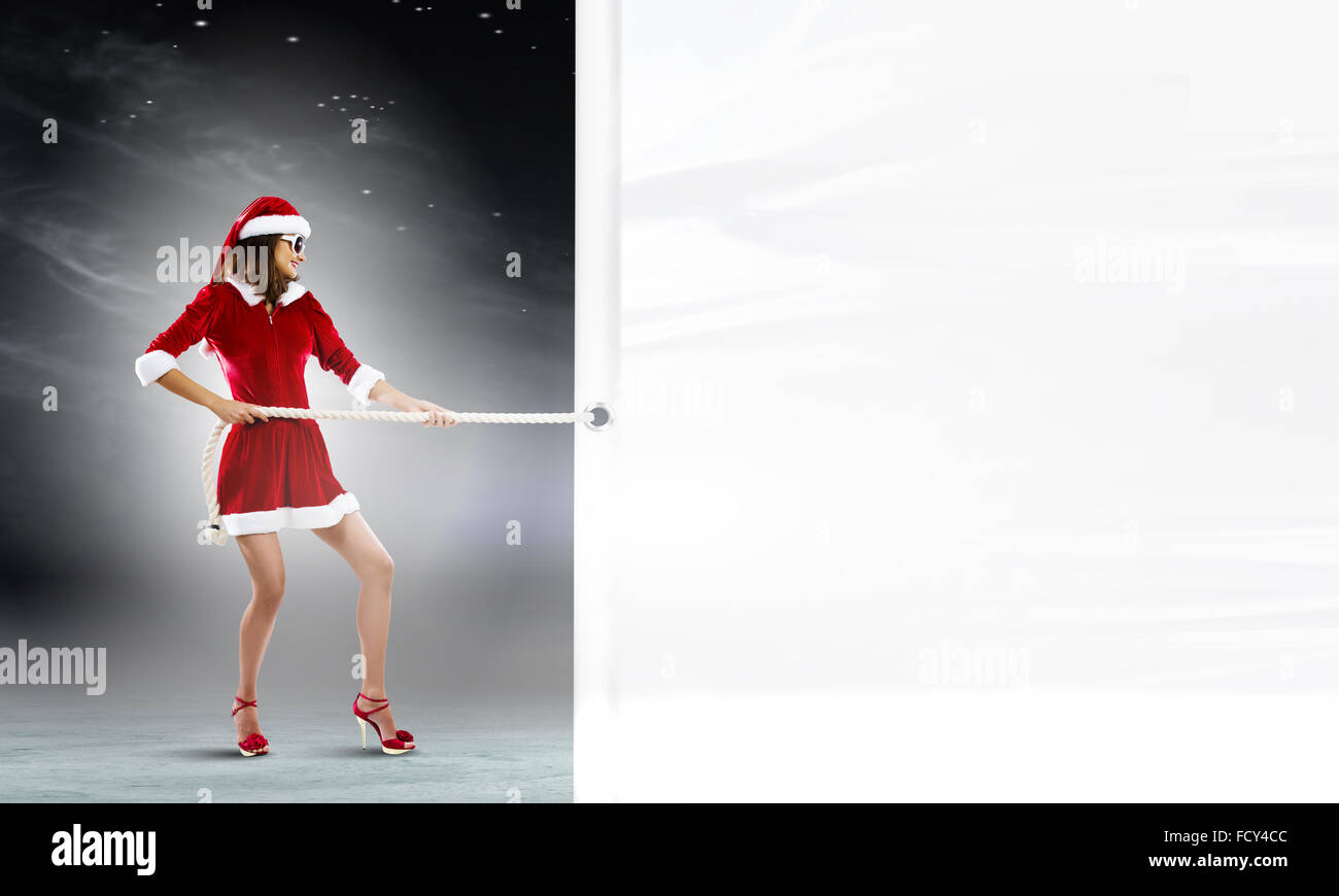 Girl in Santa costume pulling white blank banner. Place for text Stock ...