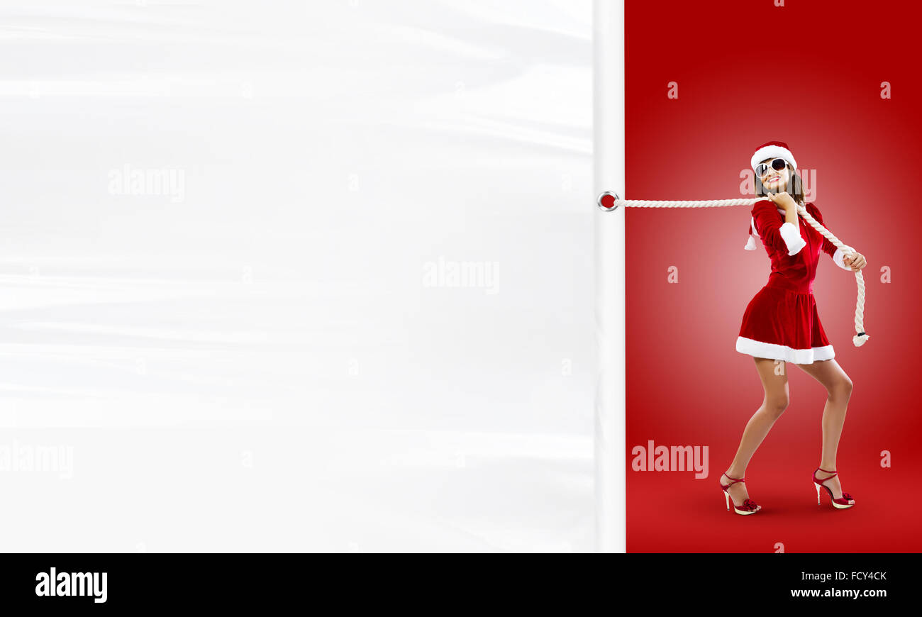 Girl in Santa costume pulling white blank banner. Place for text Stock ...