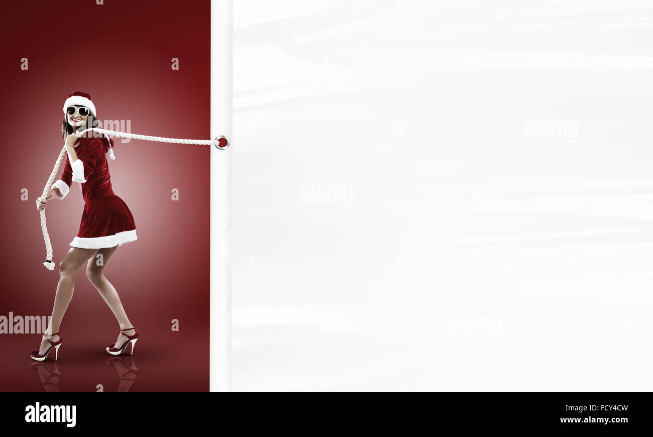 Girl in Santa costume pulling white blank banner. Place for text Stock ...