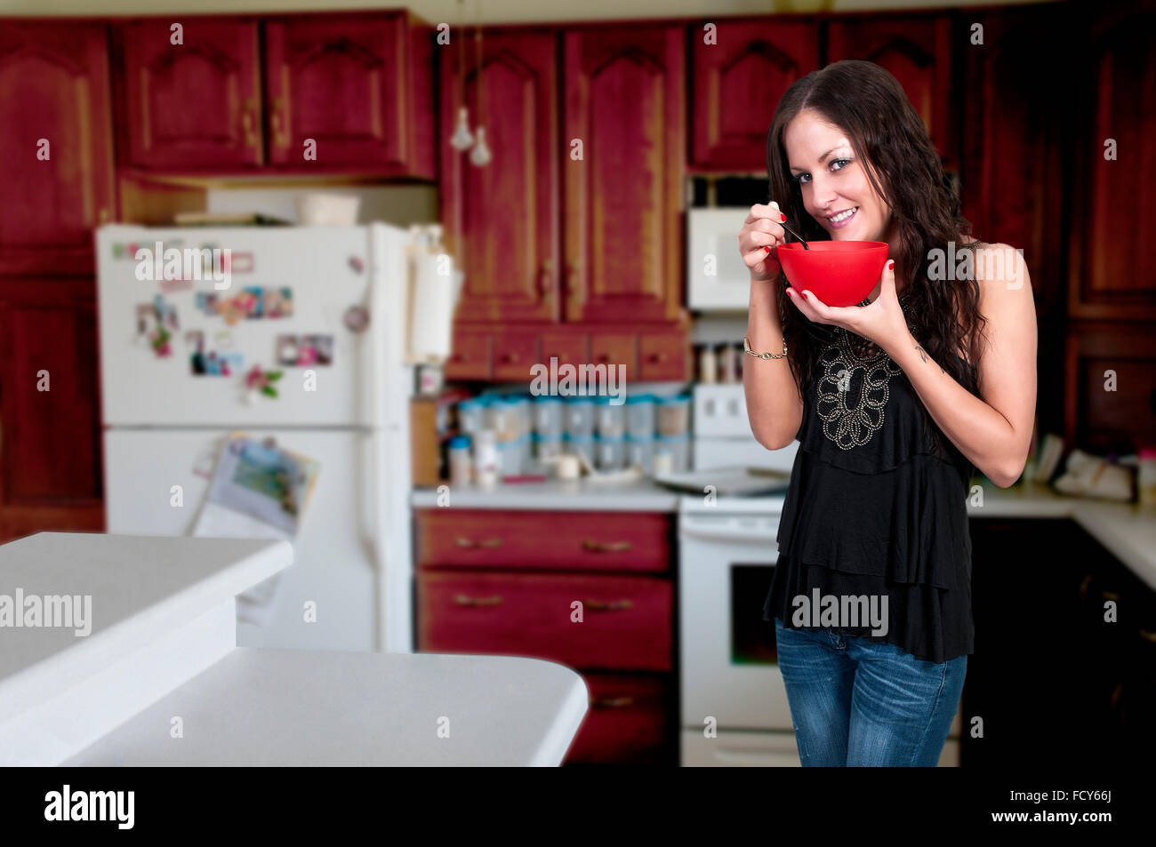 A beautiful woman eating food from a bowl Stock Photo - Alamy