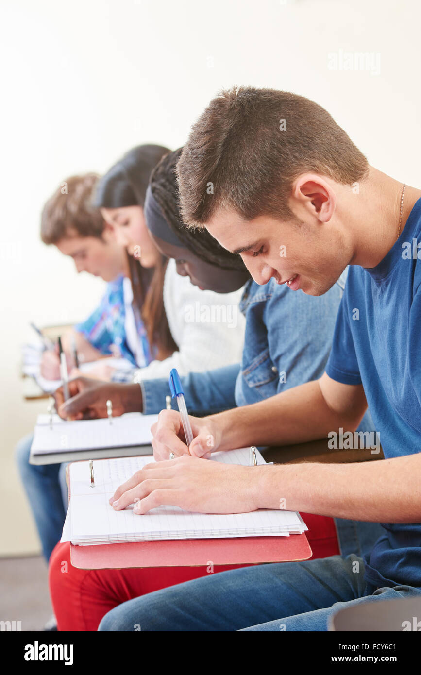 Interracial group of students take notes in university with their ...