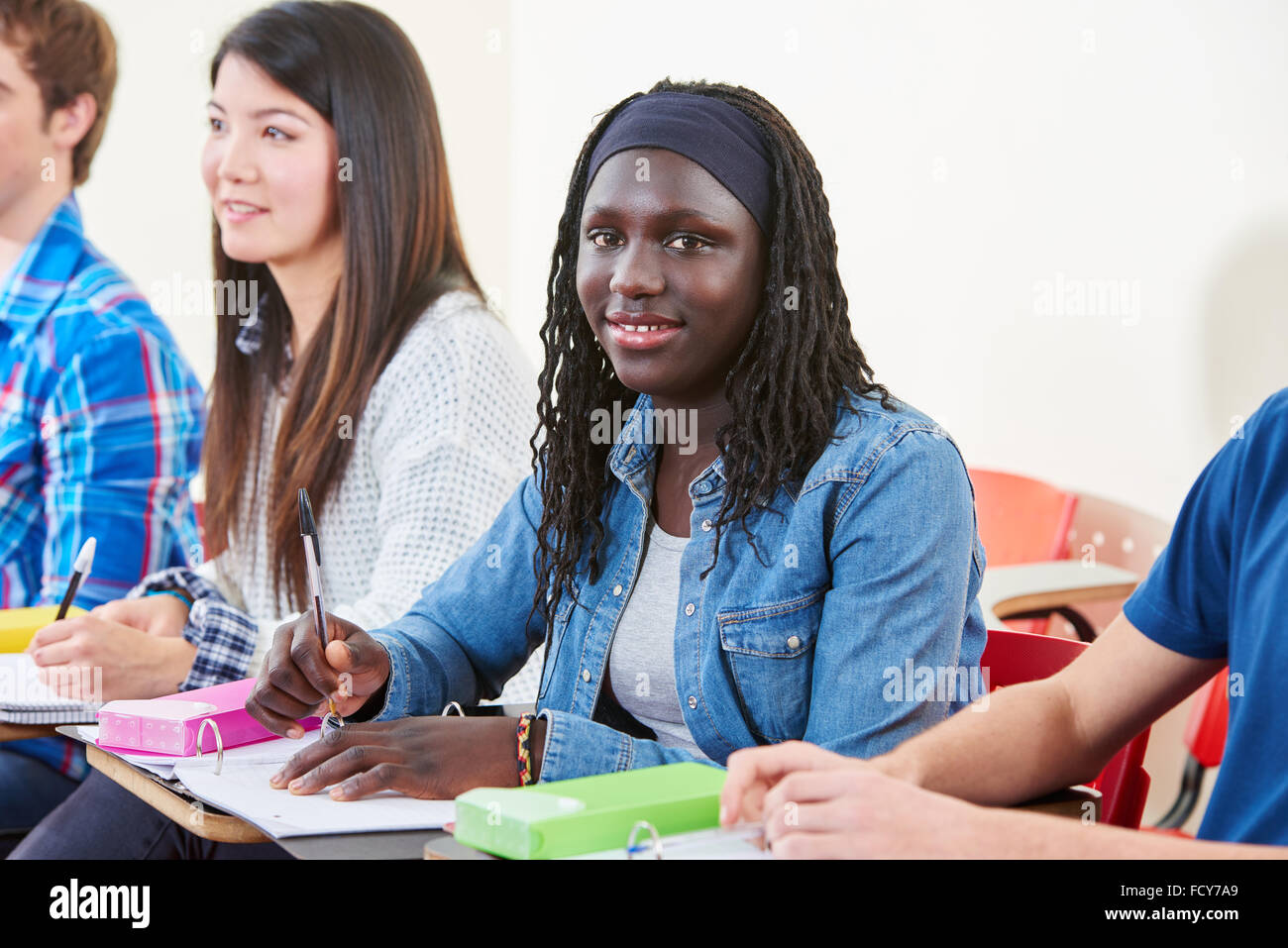 Happy african student smiling in class in university Stock Photo - Alamy