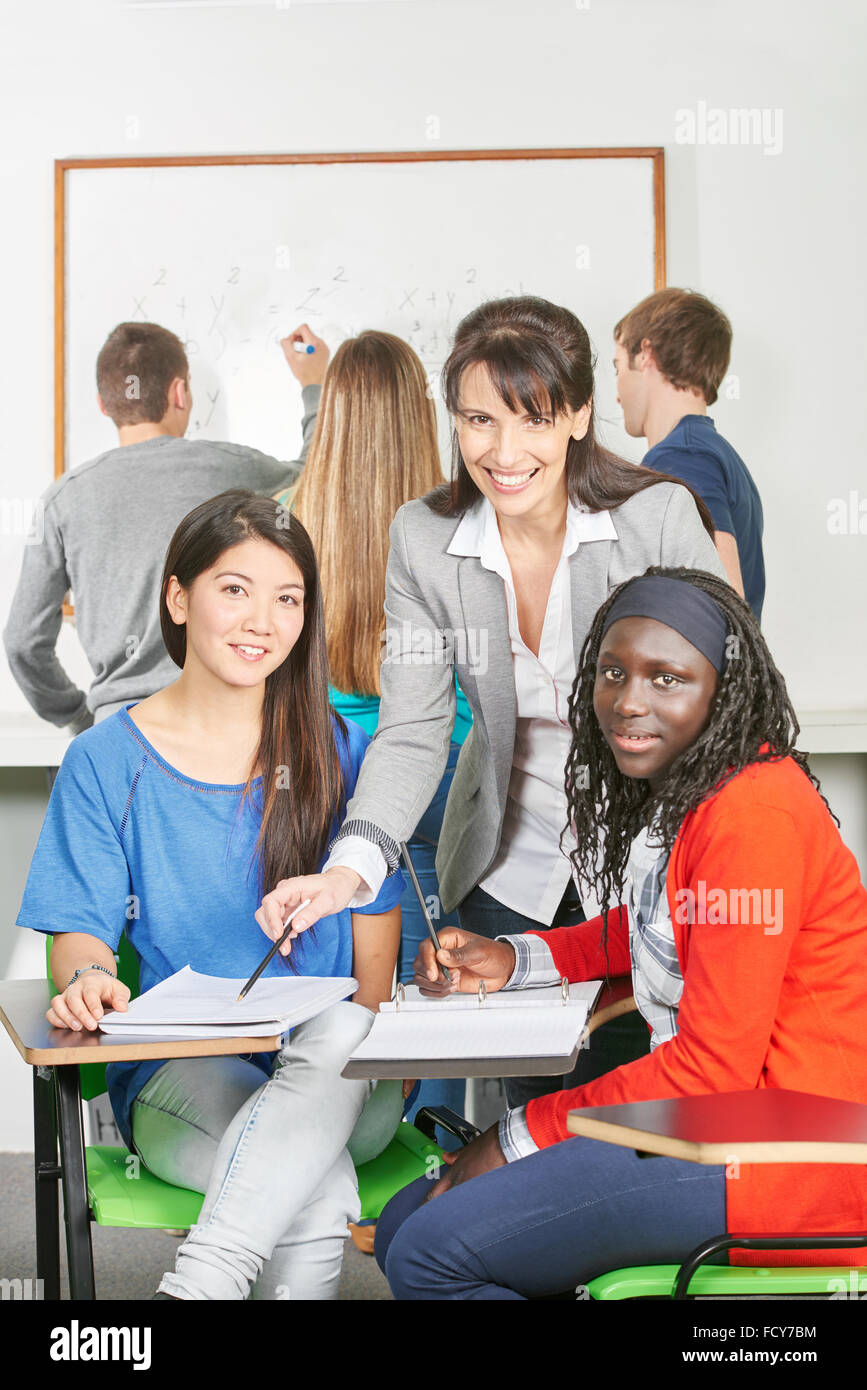 Girls learning together doing teamwork with their teacher Stock Photo ...