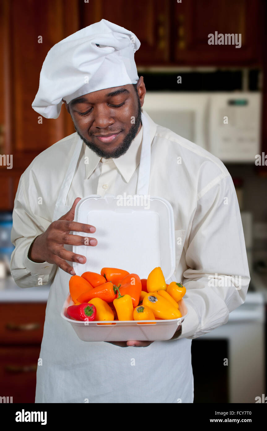 Black African American male chef holding a bowl of fresh sweet peppers ...