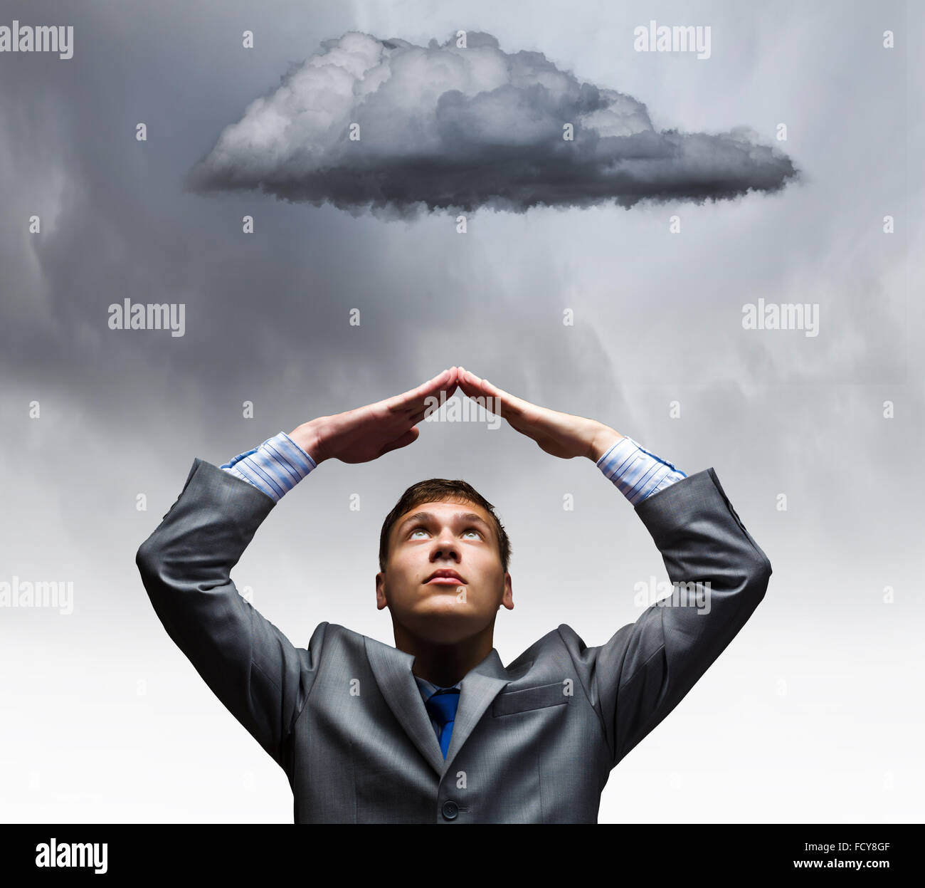 Businessman sitting under rain protecting head with arms Stock Photo ...