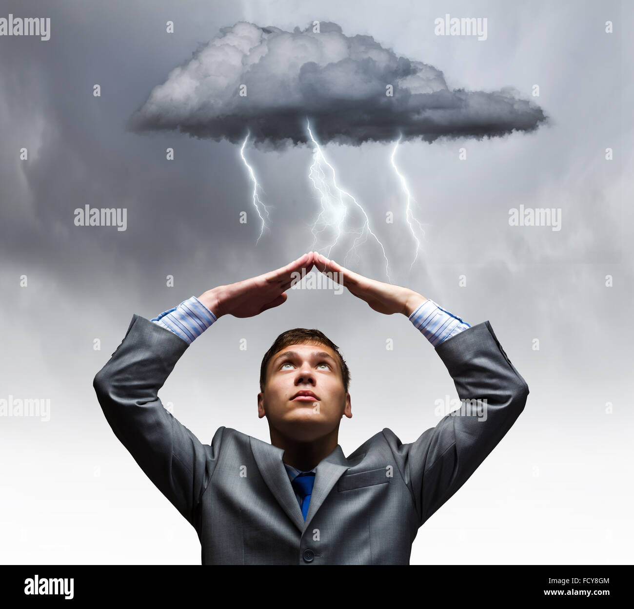 Businessman sitting under rain protecting head with arms Stock Photo ...