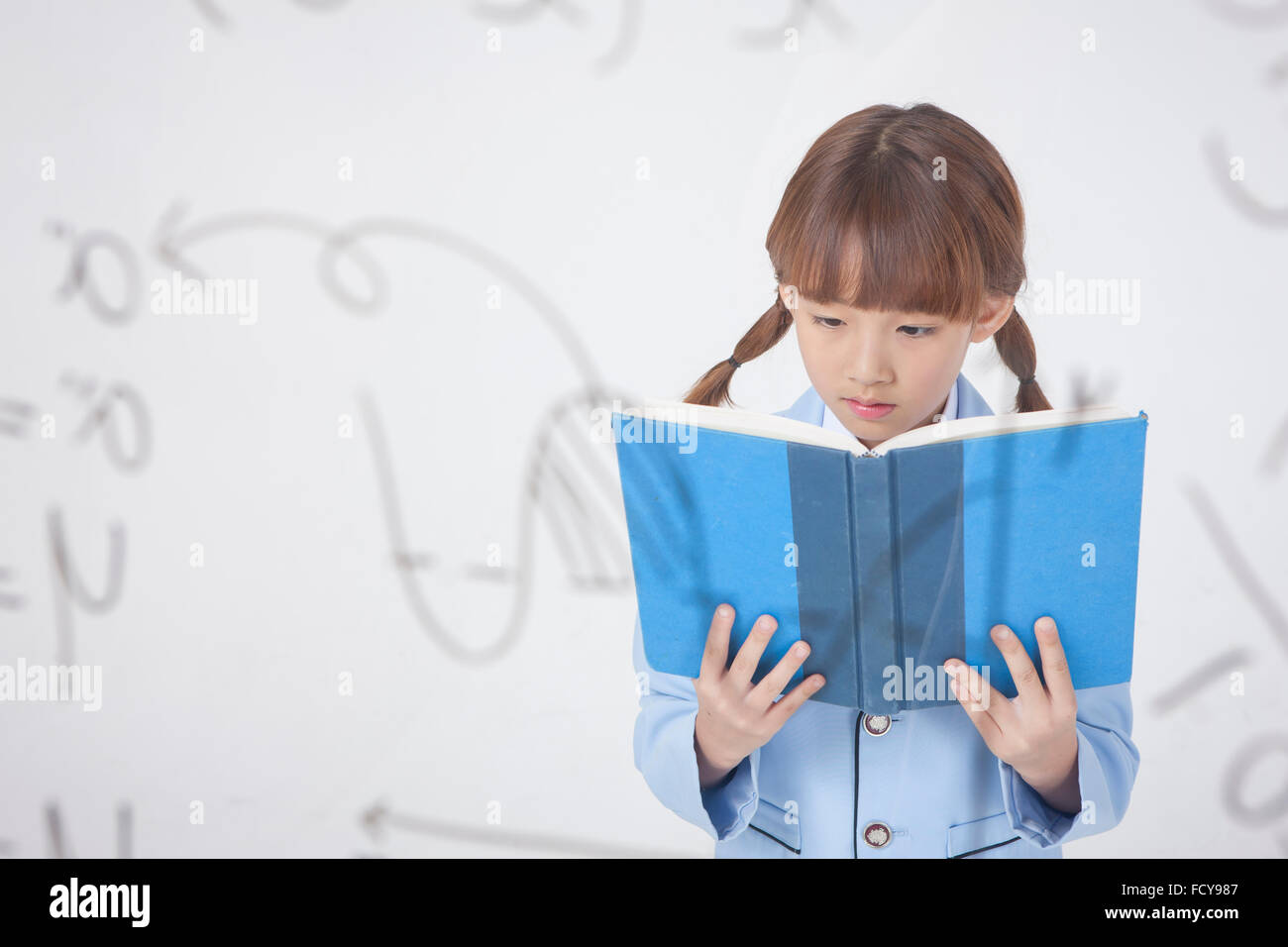 Elementary school girl in uniforms behind a transparent board with math ...
