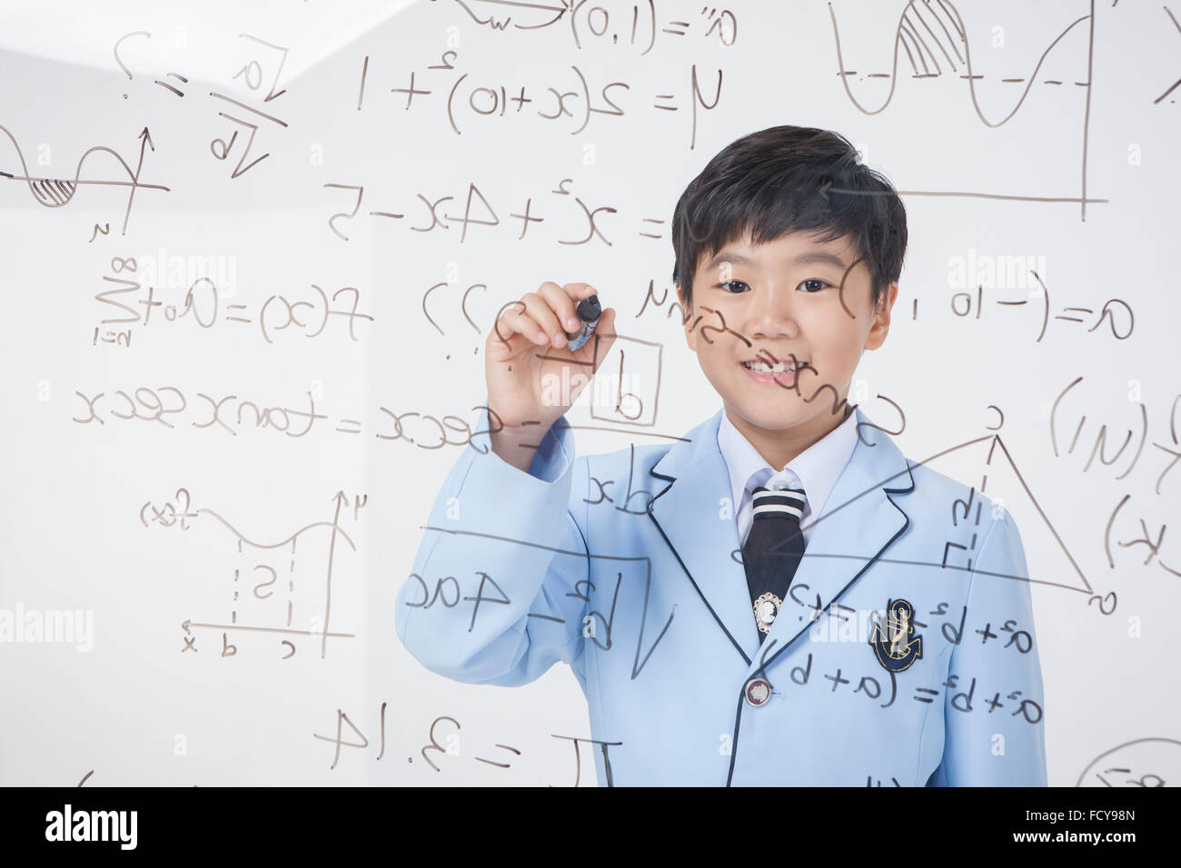 Elementary school boy in uniforms behind transparent board with math ...