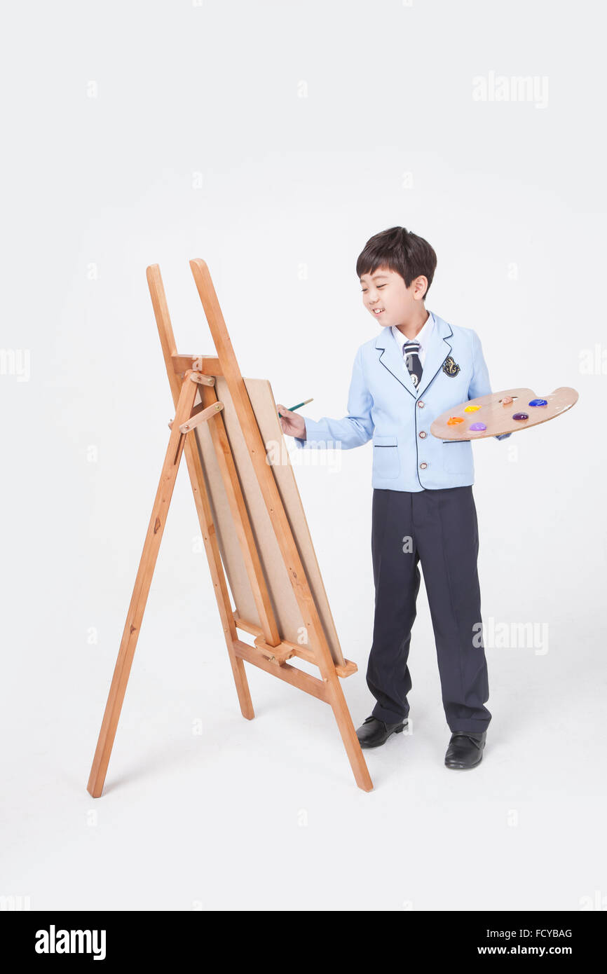 Elementary school boy in school uniforms standing and drawing with a ...
