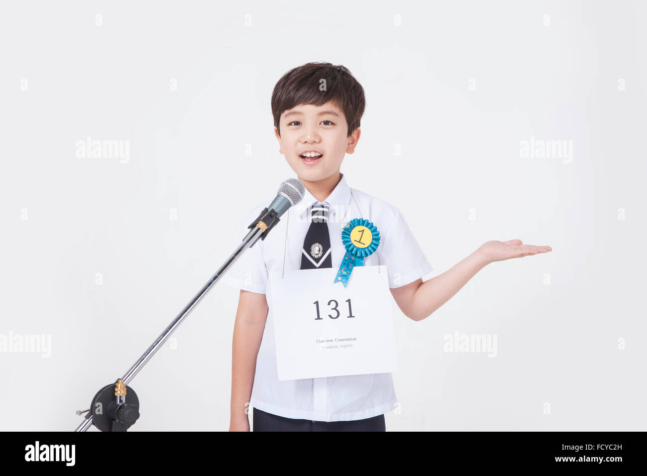 Elementary school boy giving a presentation on a microphone wearing a ...