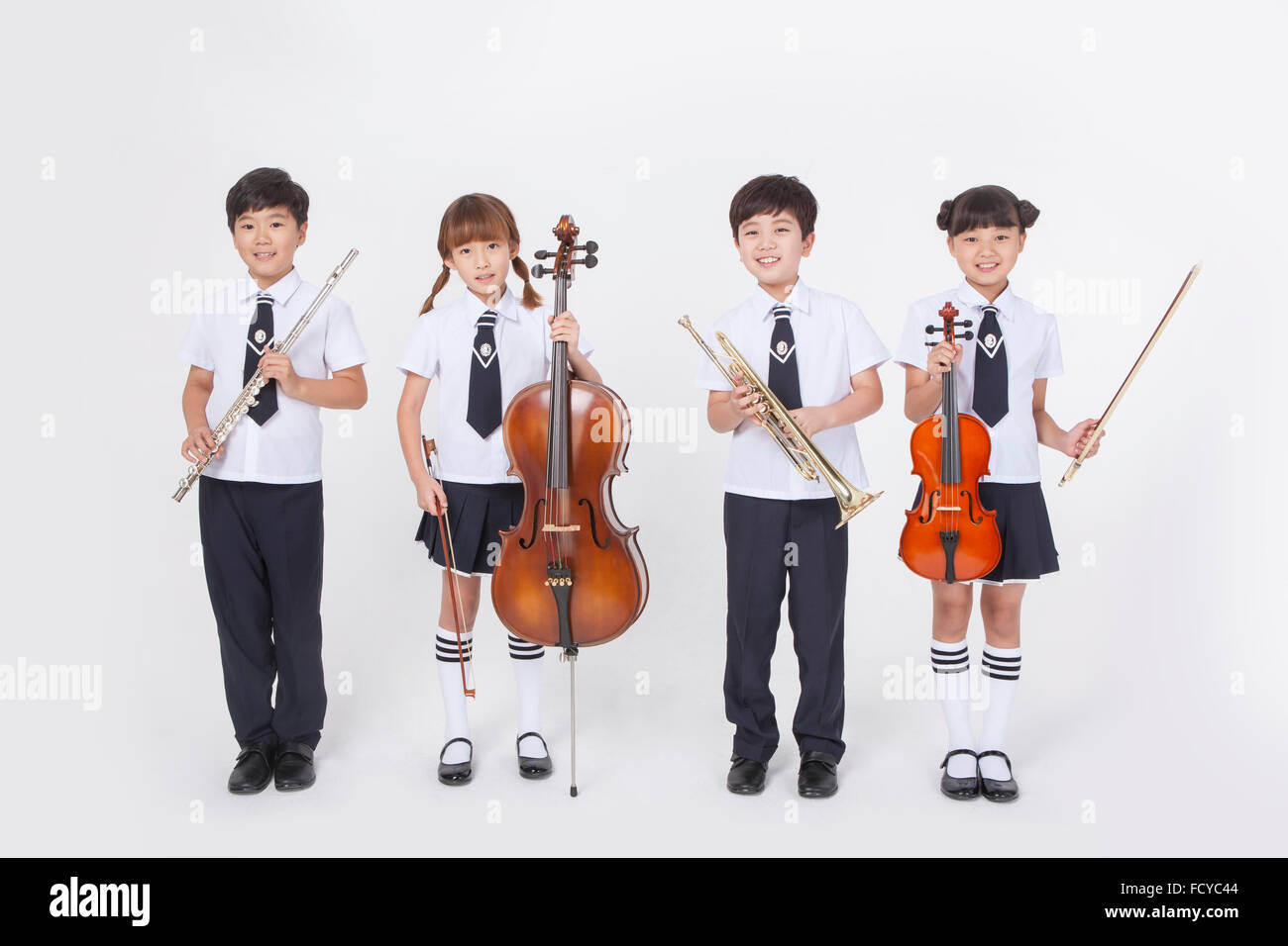 Four elementary school students in school uniforms standing with a ...