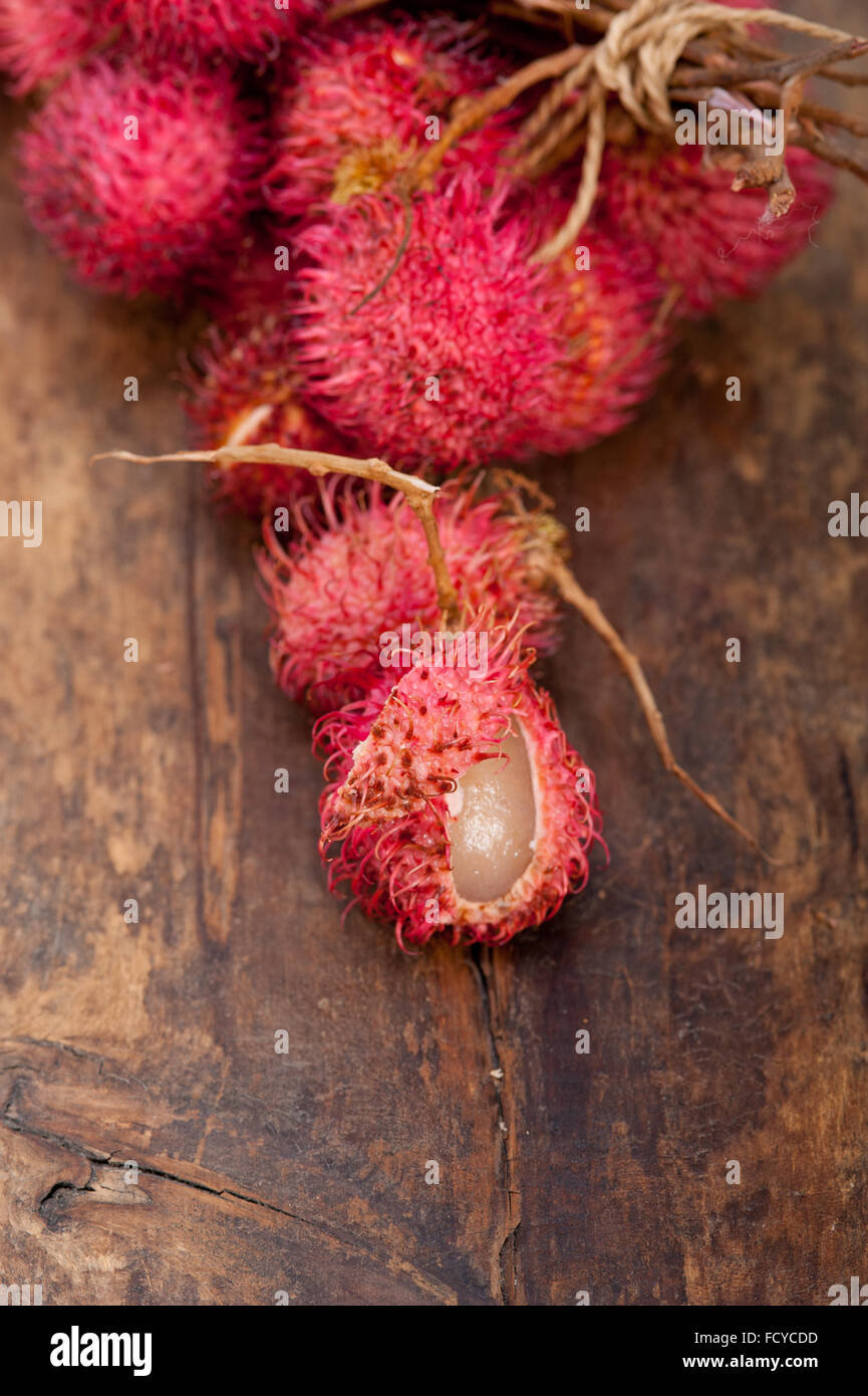 fresh tropical rambutan fruits over rustic wood table Stock Photo - Alamy