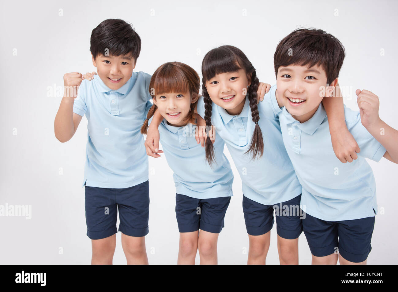 Four elementary school students in sportswear putting their arms around ...