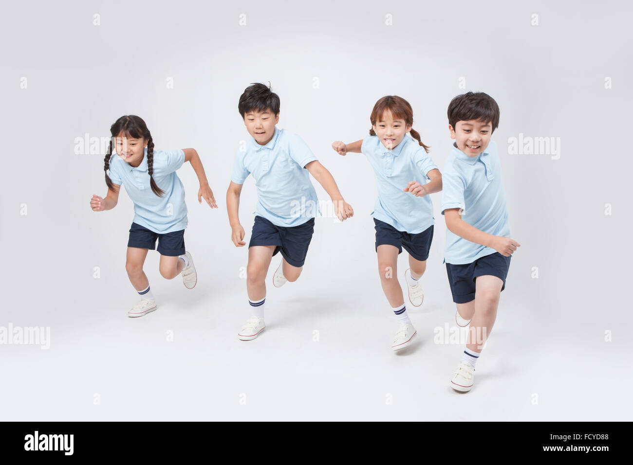 Four elementary school students in sportswear running together Stock ...