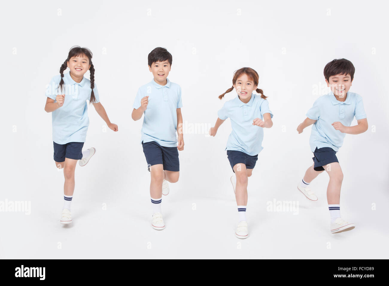 Four elementary school students in sportswear running together Stock ...