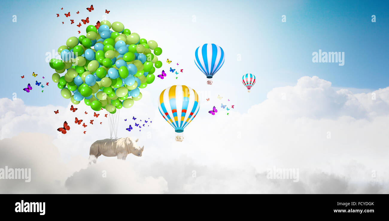 Rhino flying high in sky on bunch of colorful balloons Stock Photo - Alamy