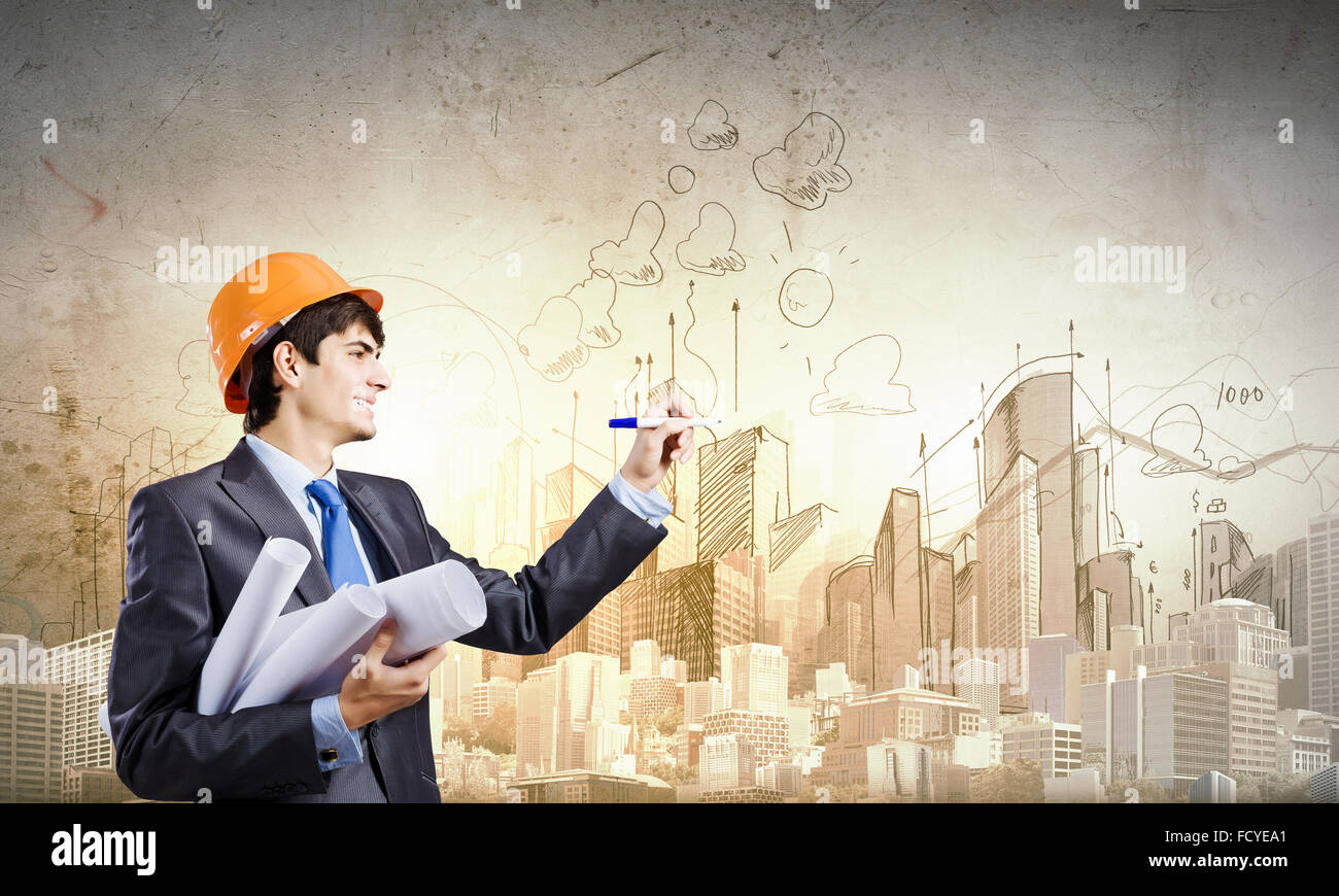 Young man engineer in helmet drawing construction project Stock Photo ...