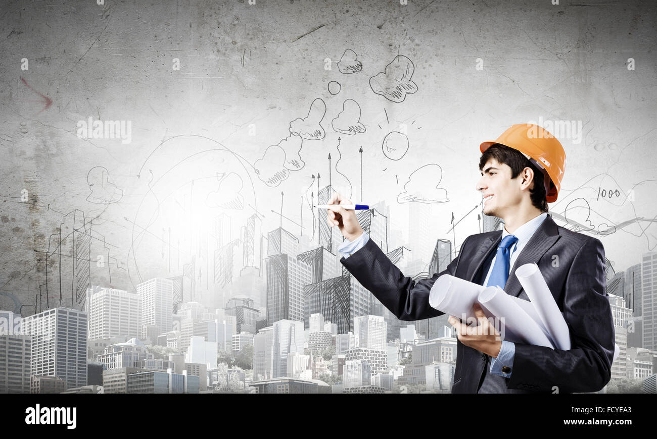 Young man engineer in helmet drawing construction project Stock Photo - Alamy