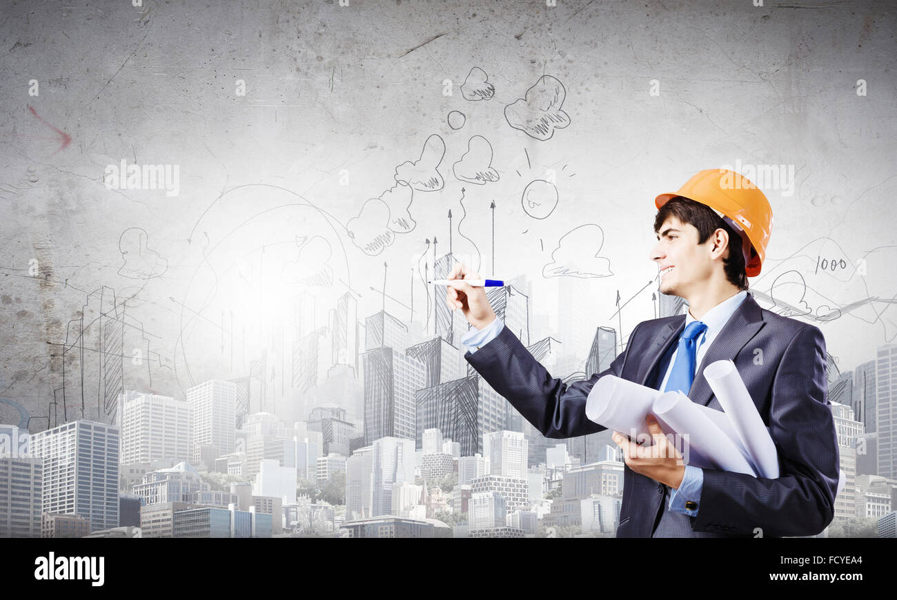 Young man engineer in helmet drawing construction project Stock Photo ...