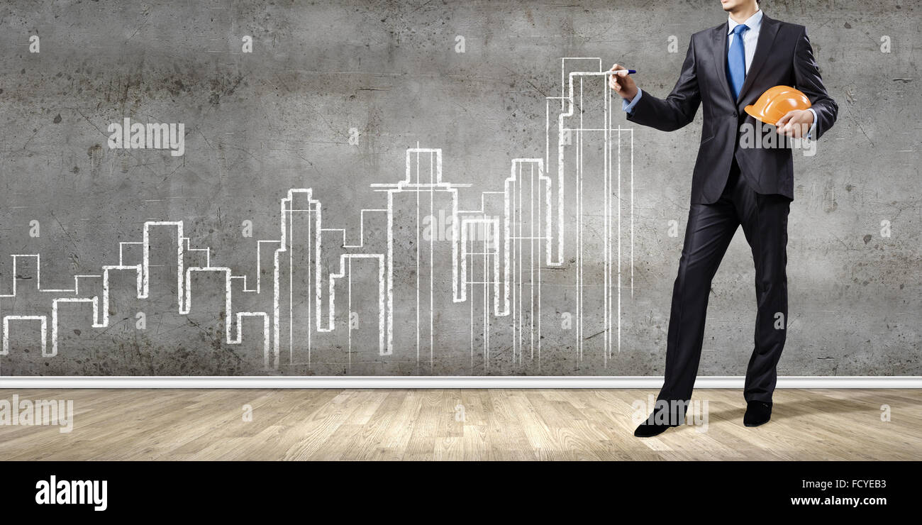 Young man engineer in helmet drawing construction project Stock Photo ...