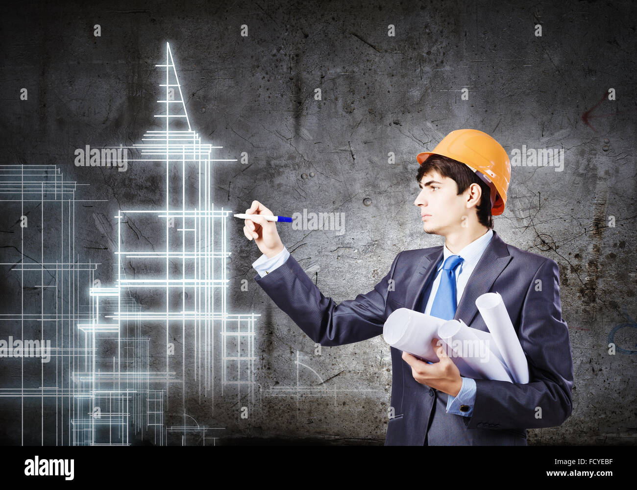 Young man engineer in helmet drawing construction project Stock Photo ...