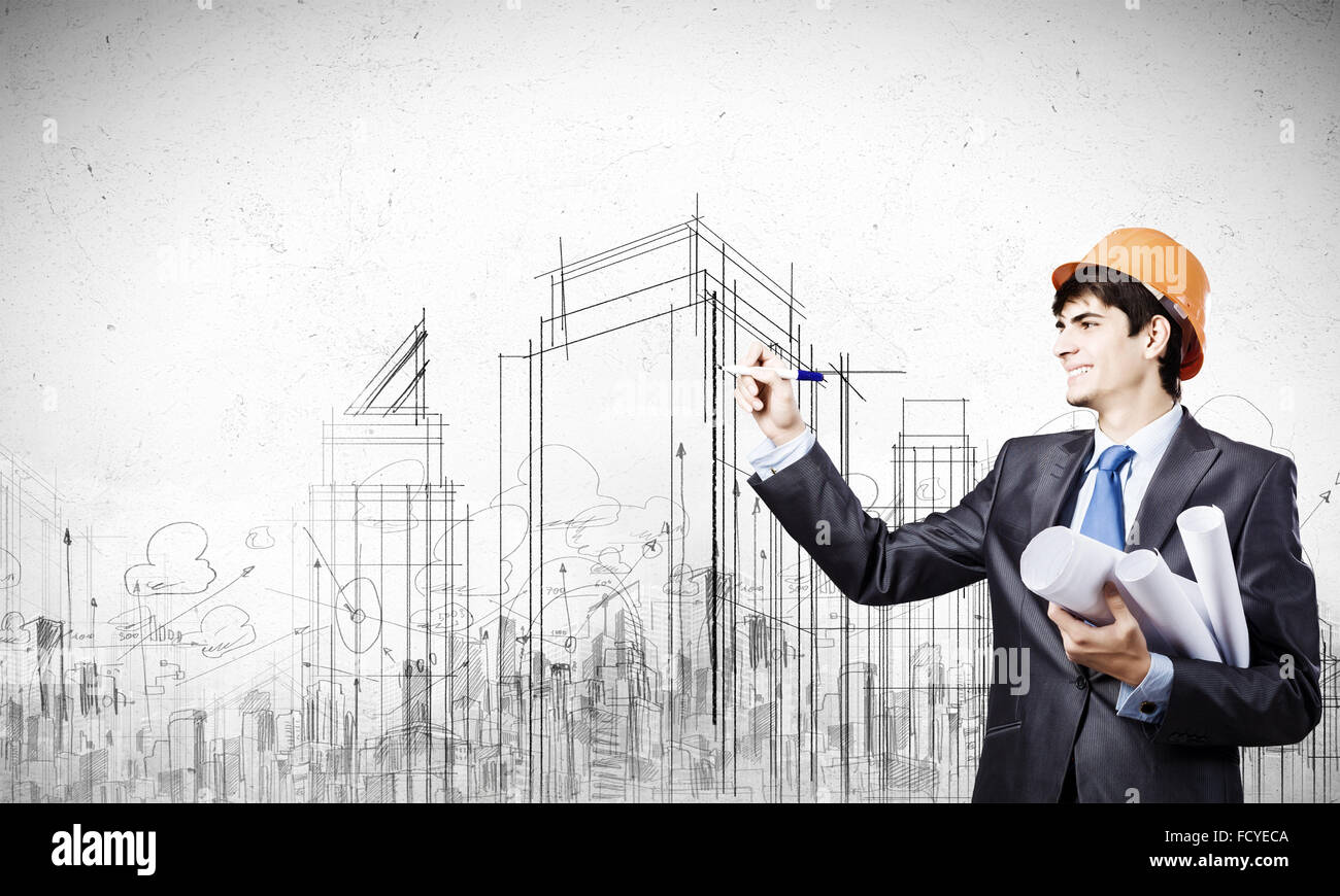 Young man engineer in helmet drawing construction project Stock Photo ...