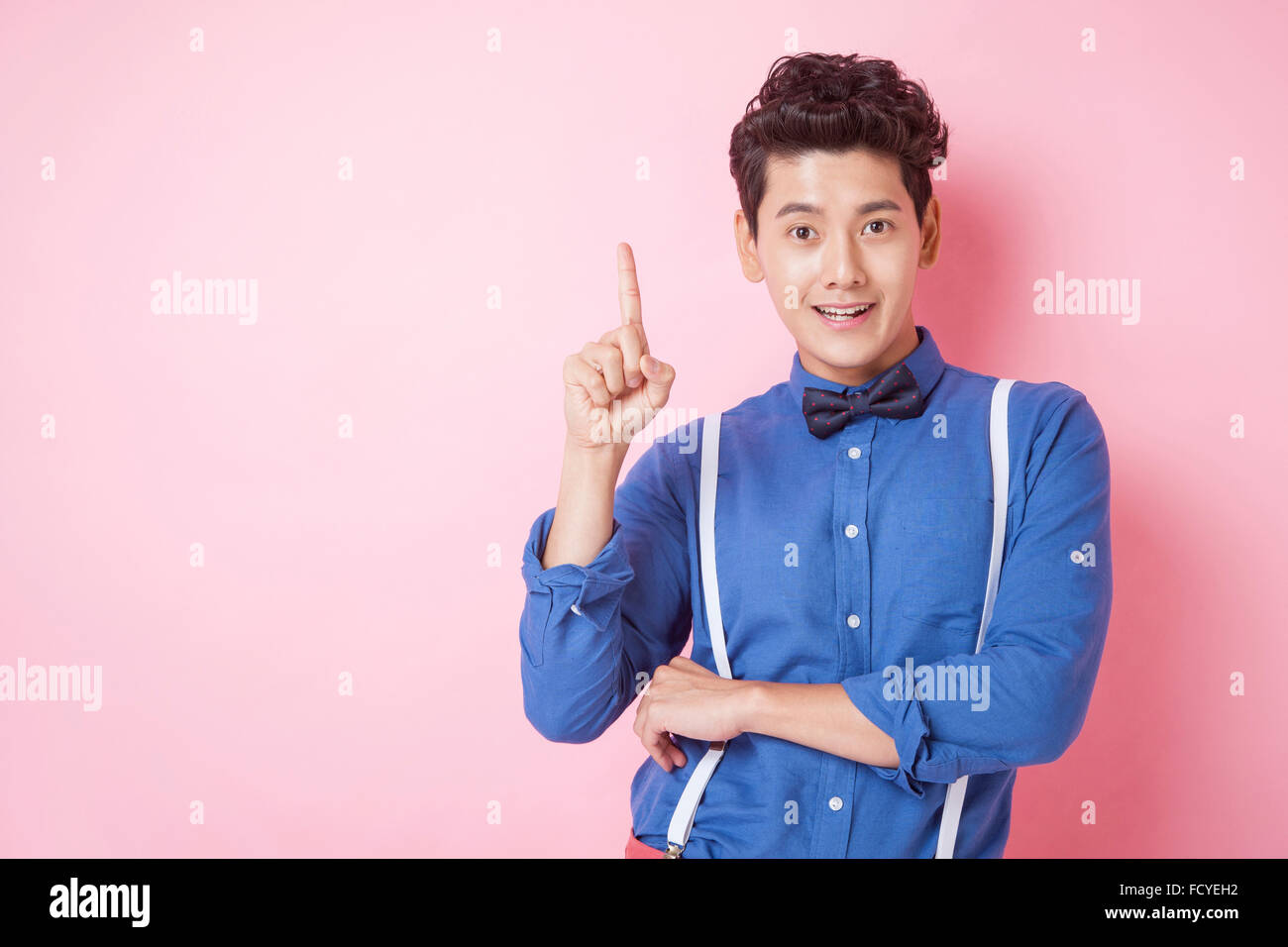 Man in retro style fashion staring forward with his finger pointing up ...