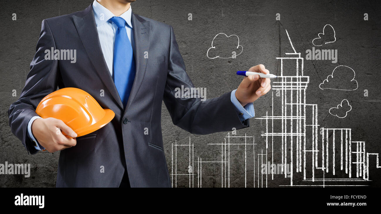 Young man engineer in helmet drawing construction project Stock Photo ...