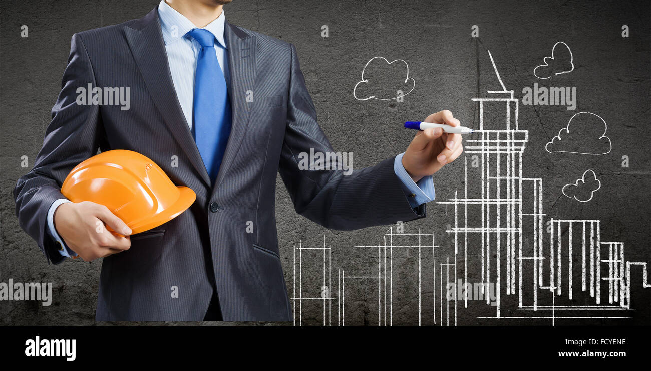 Young man engineer in helmet drawing construction project Stock Photo ...