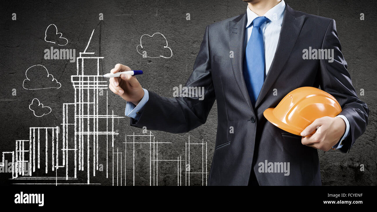 Young man engineer in helmet drawing construction project Stock Photo ...