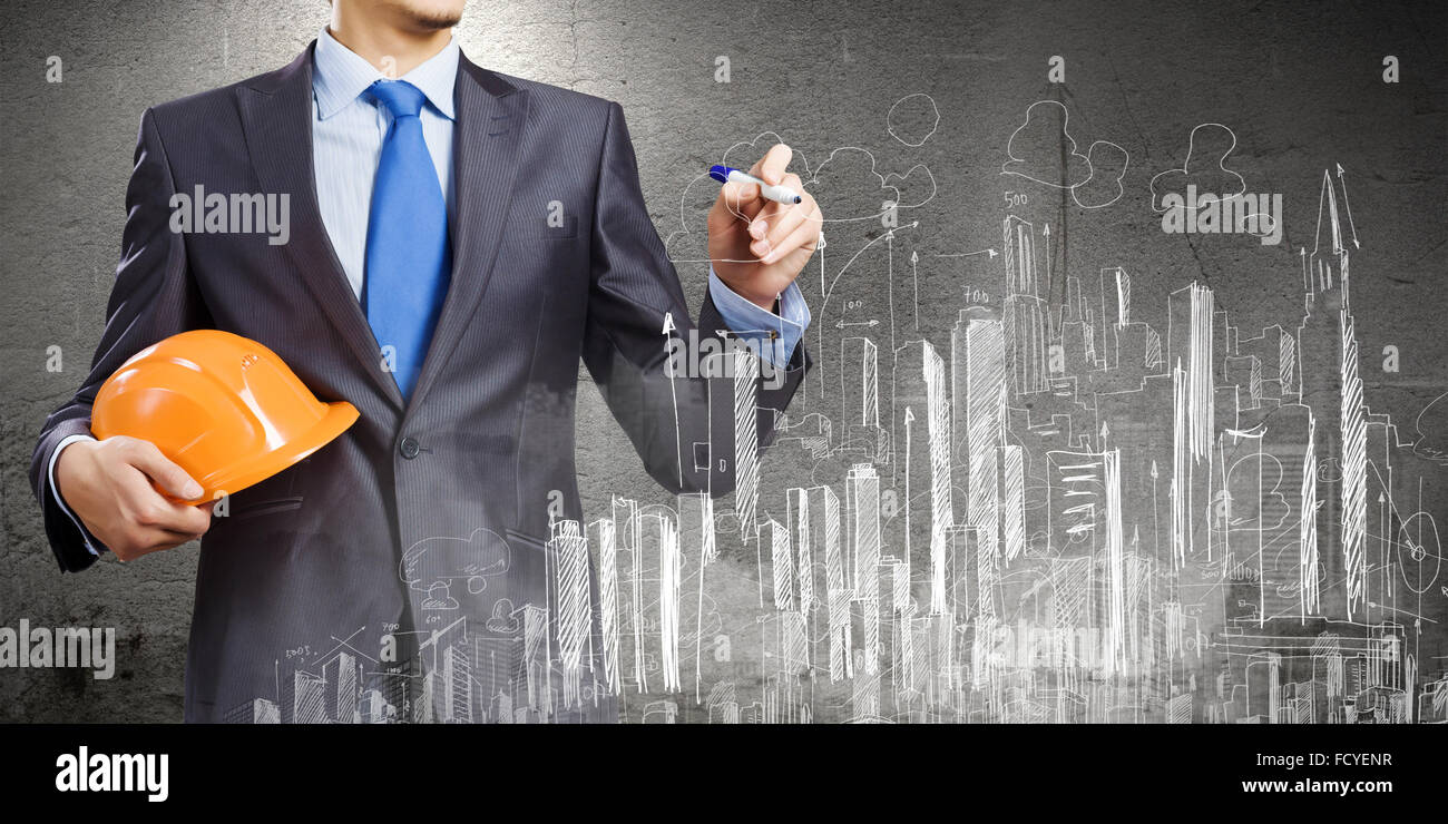 Young man engineer in helmet drawing construction project Stock Photo ...