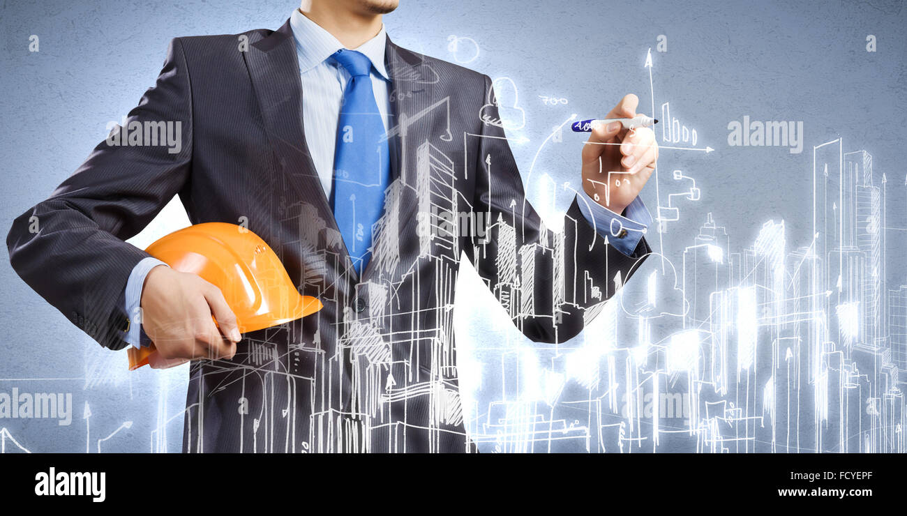 Young man engineer in helmet drawing construction project Stock Photo ...