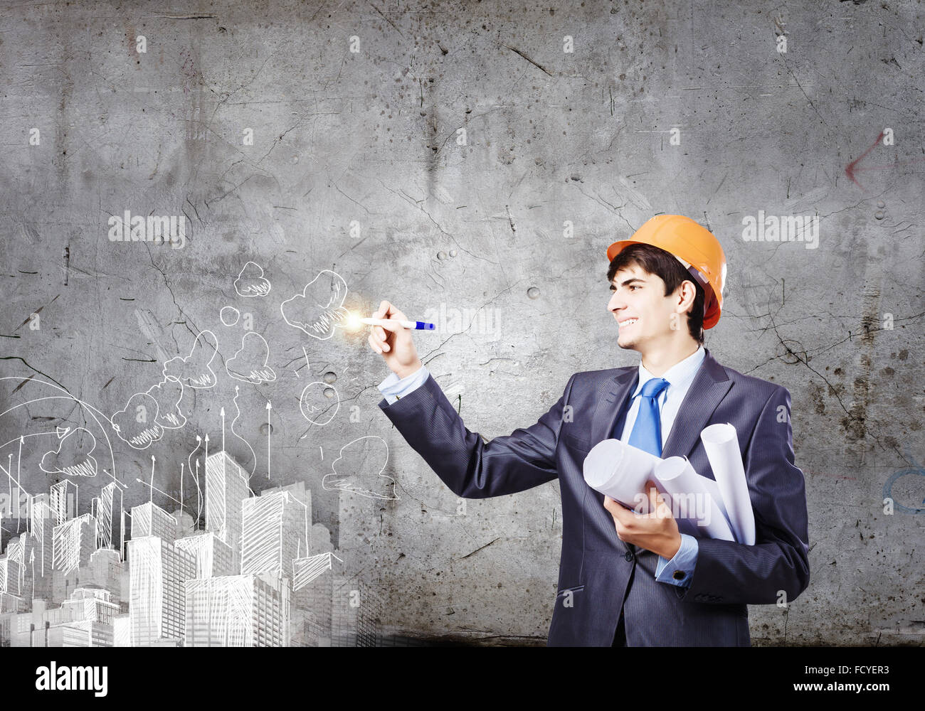 Young man engineer in helmet drawing construction project Stock Photo ...