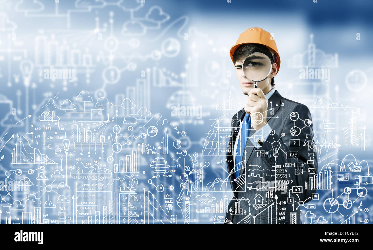 Young man engineer with magnifier against sketch background Stock Photo - Alamy