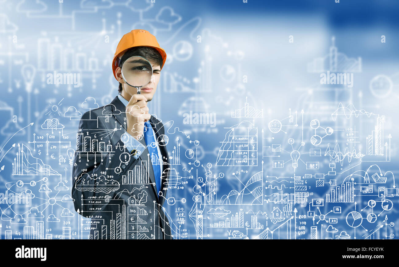 Young man engineer with magnifier against sketch background Stock Photo ...