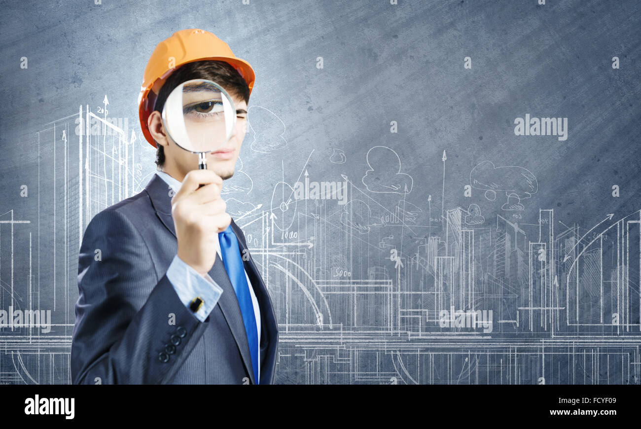 Young man engineer with magnifier against sketch background Stock Photo ...