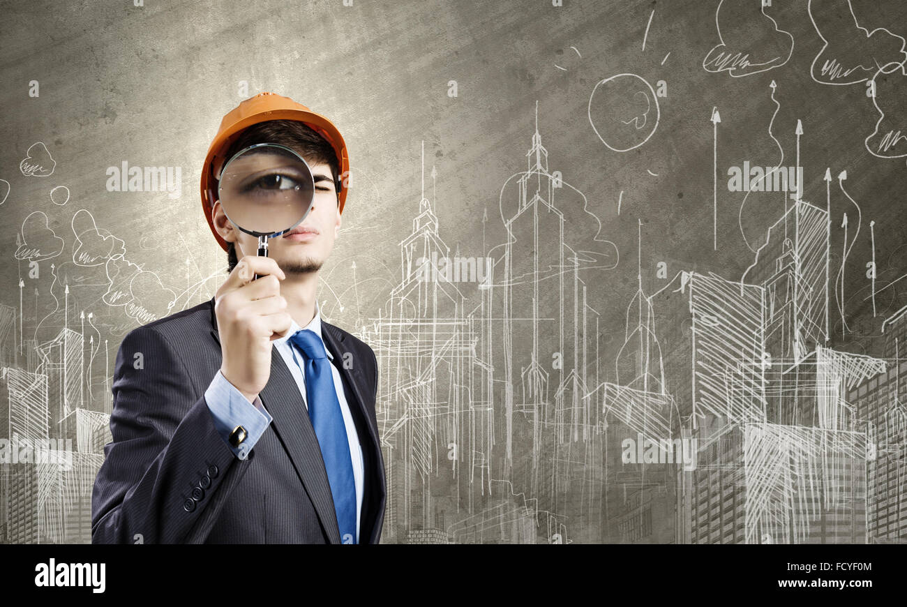 Young man engineer with magnifier against sketch background Stock Photo ...