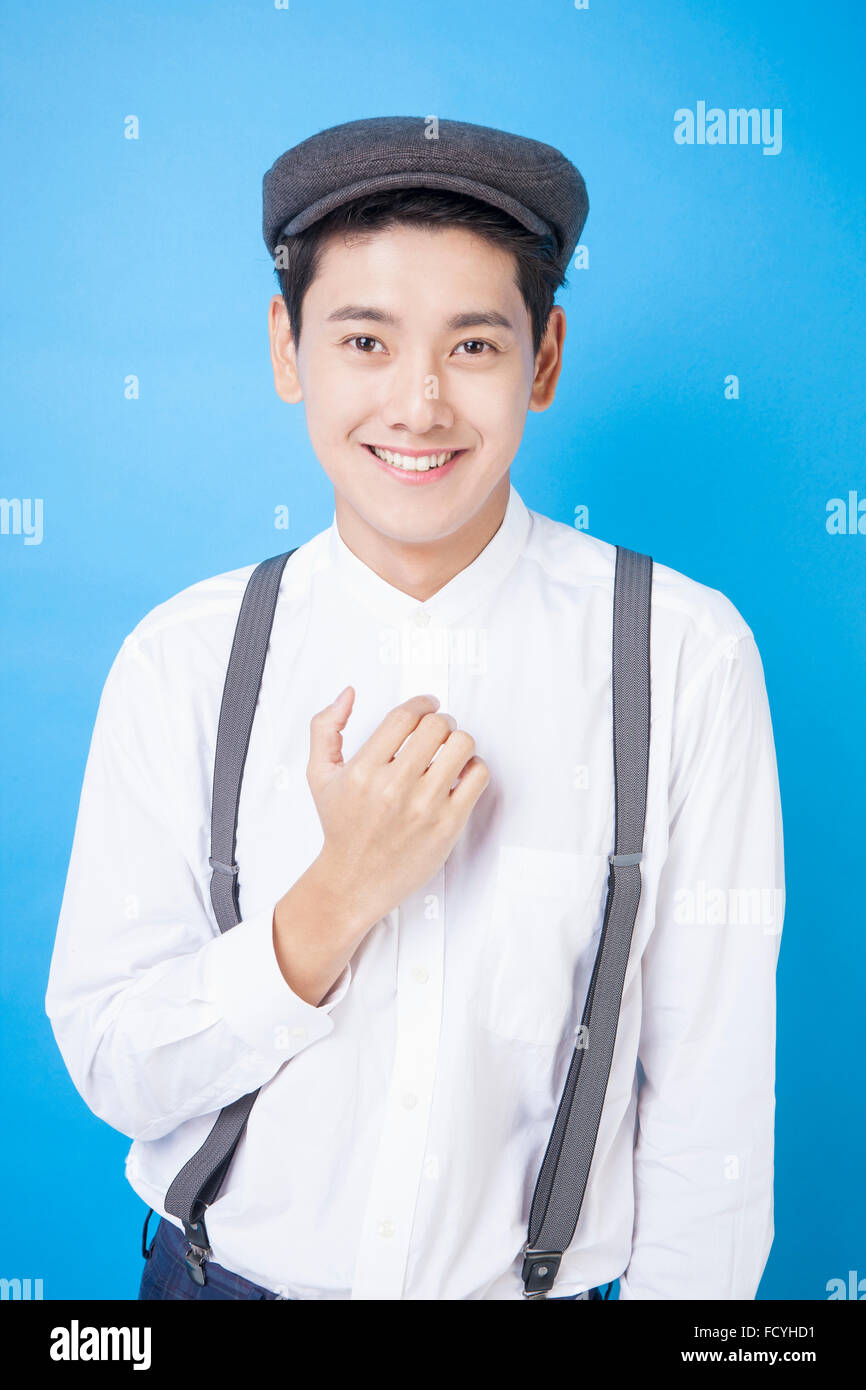 Man in retro style fashion staring forward with a smile on blue ...