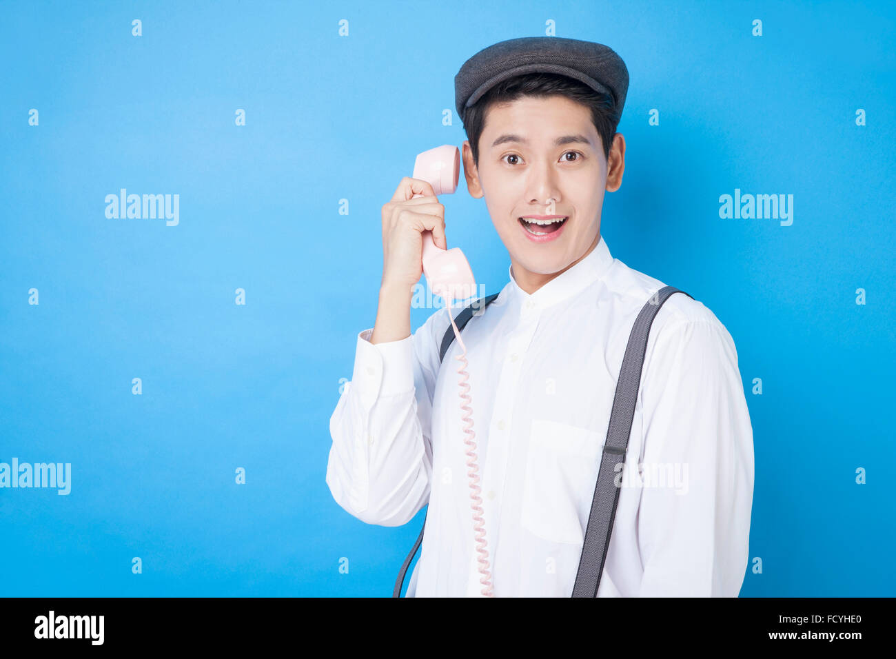 Man in retro style fashion gesturing taking a phone call in surprise on ...