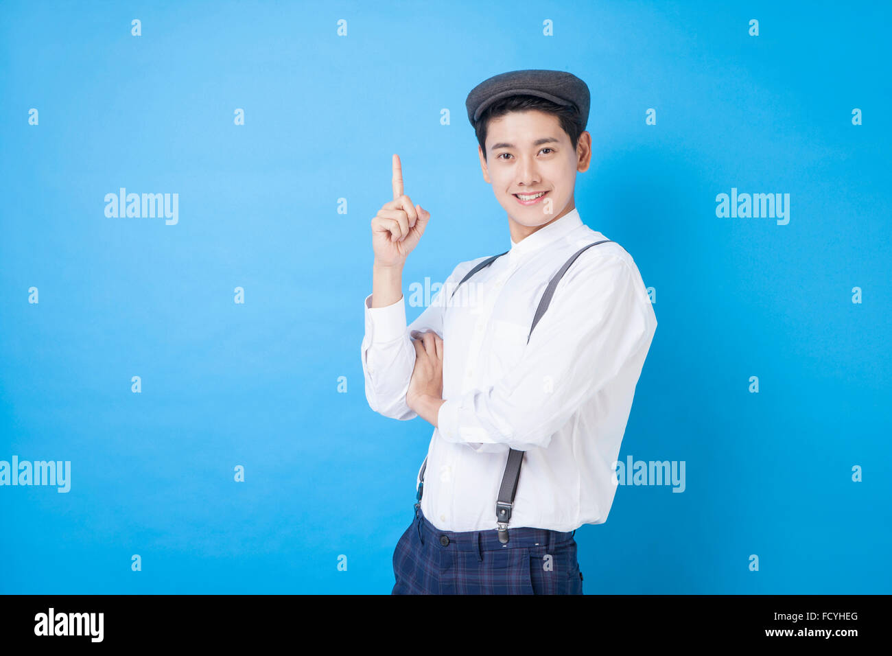 Man in retro style fashion pointing up with his finger and staring ...