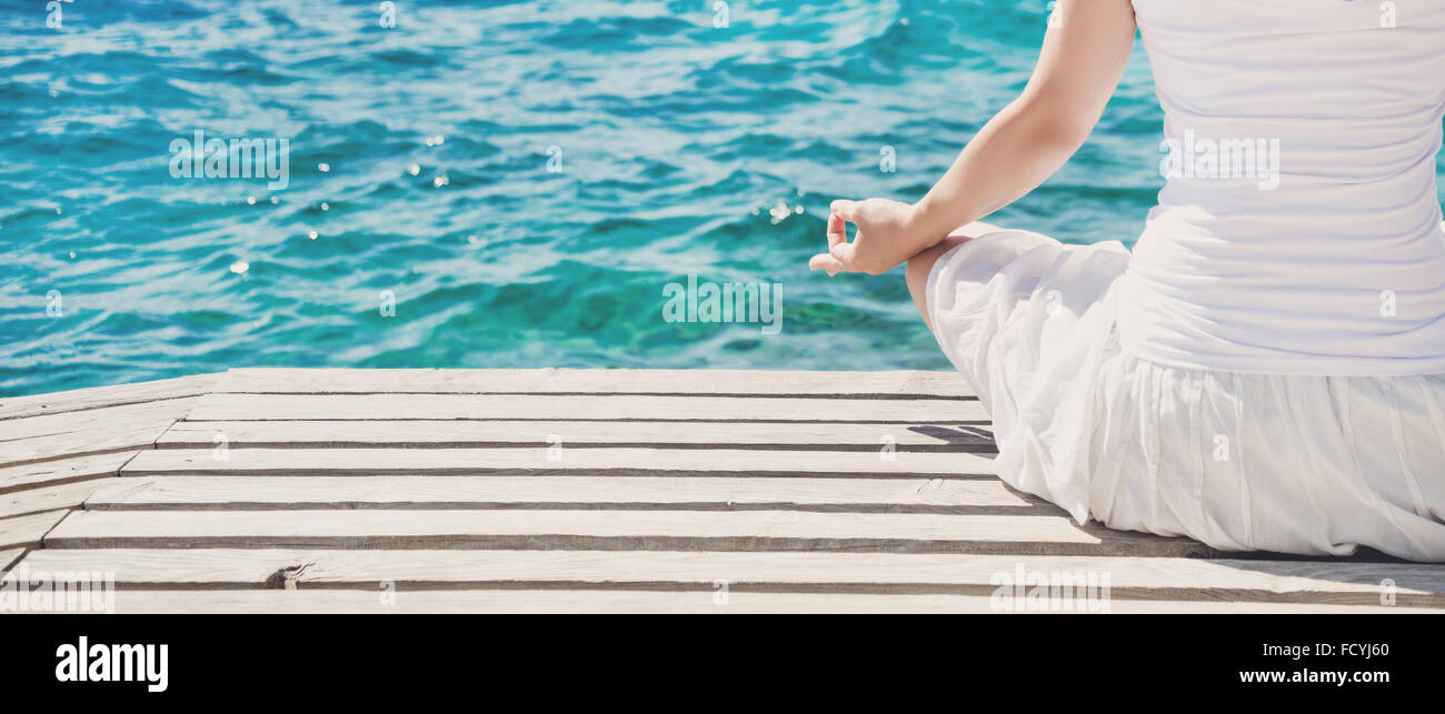 Woman meditating at the sea Stock Photo - Alamy