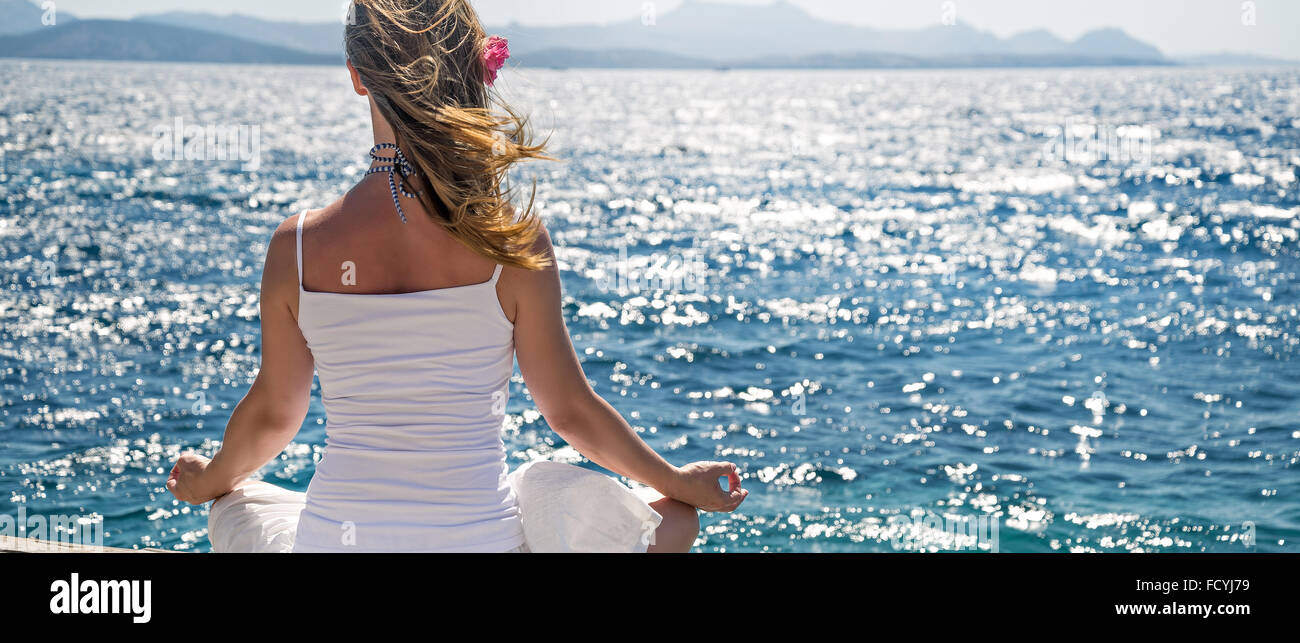 Woman meditating at the sea Stock Photo - Alamy