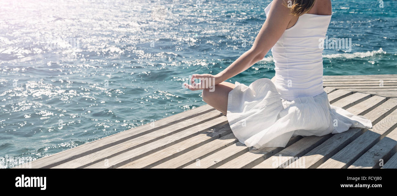 Woman meditating at the sea Stock Photo - Alamy