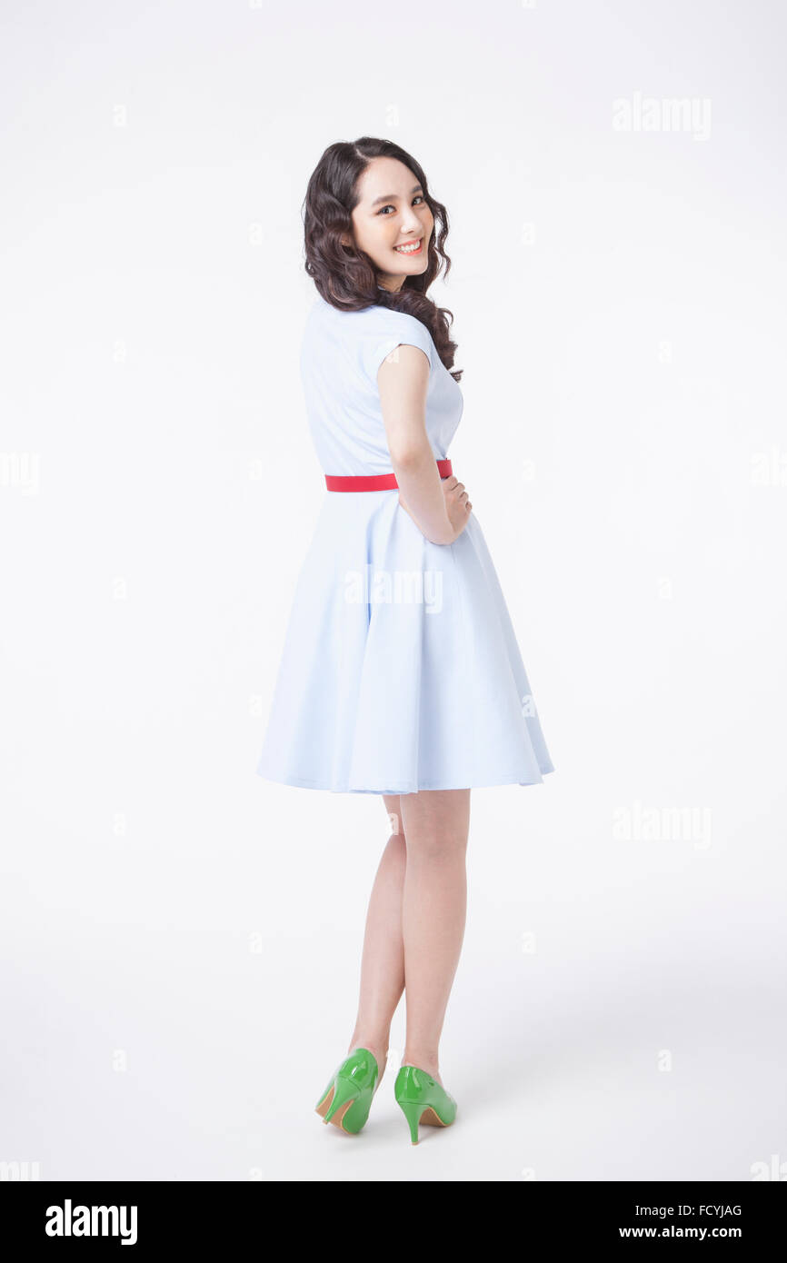 Woman in retro style standing and looking back with a smile Stock Photo ...