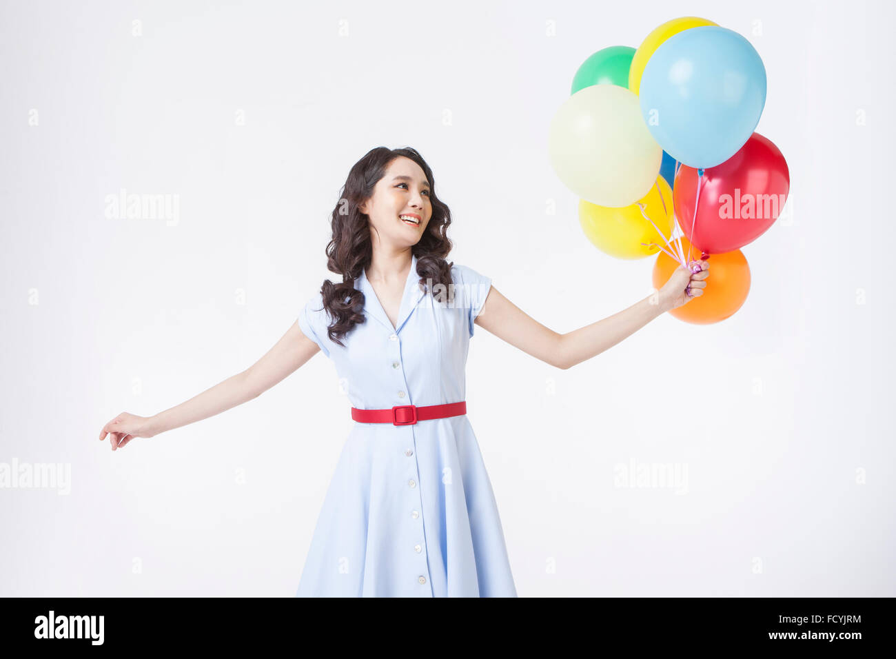 Woman in retro style outfits staring upward with a smile with colorful ...