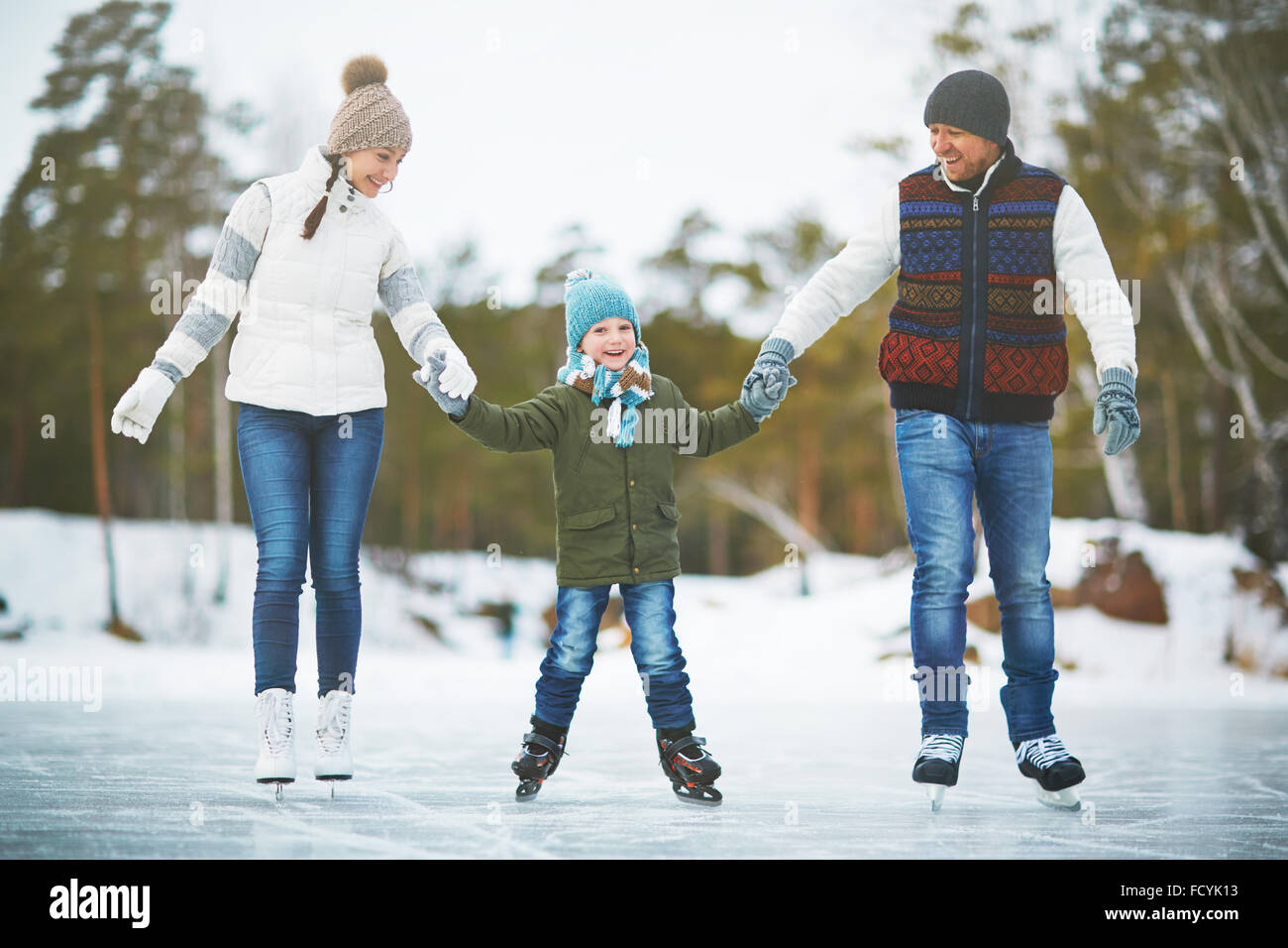 Cute boy and his parents skating together on the rink Stock Photo - Alamy