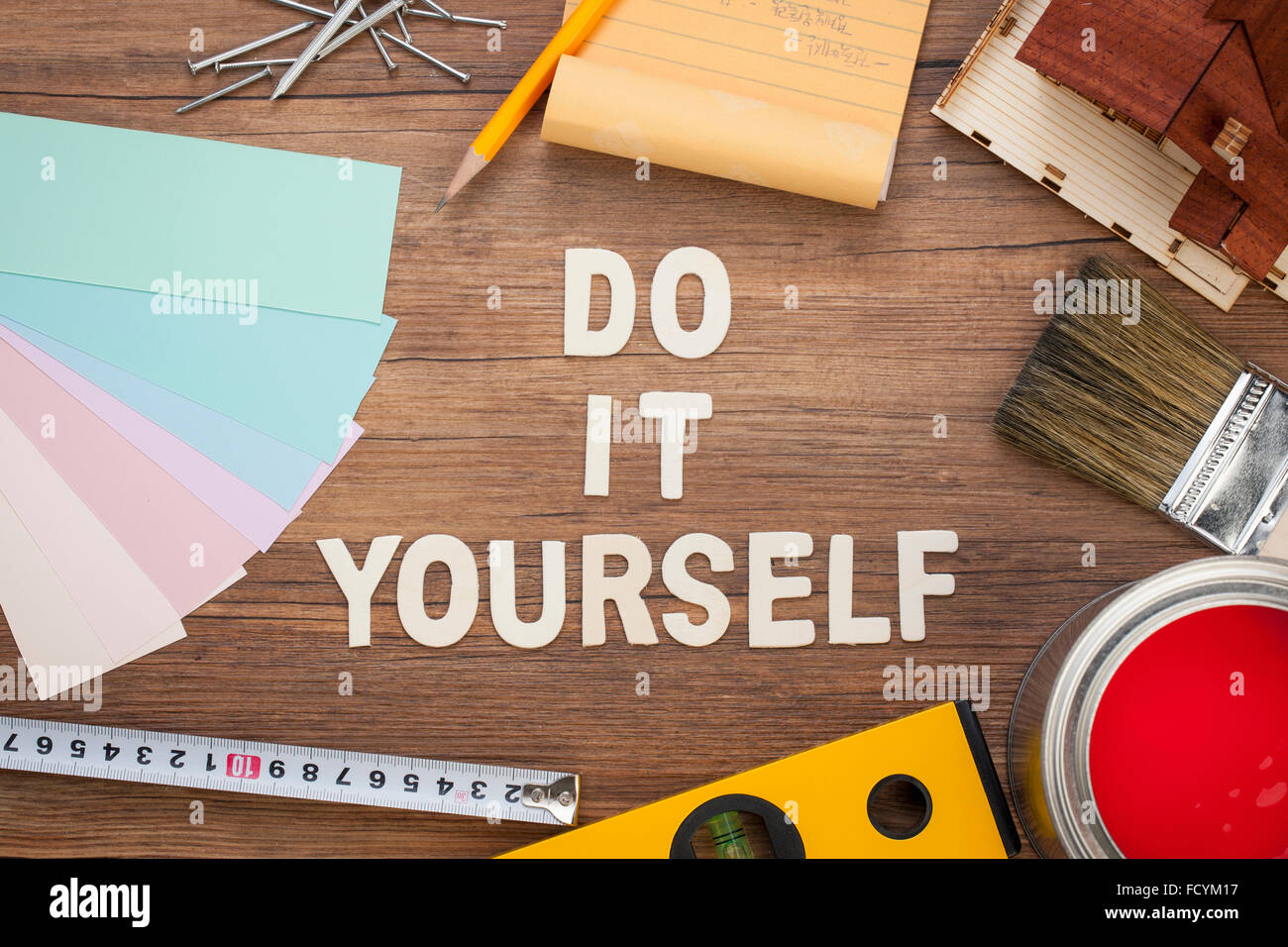 High angle of words DO IT YOURSELF on wood background framed by various ...