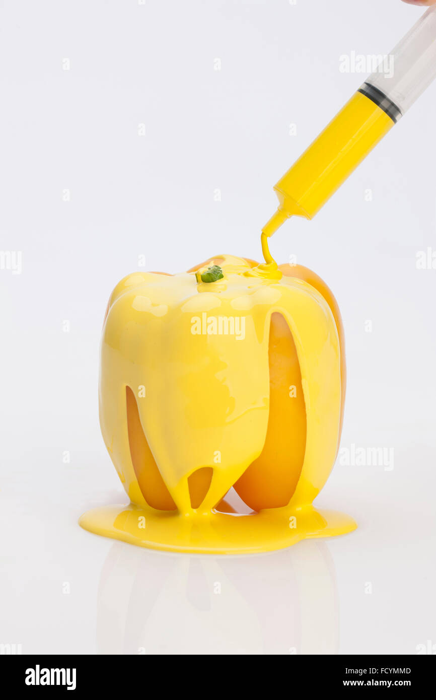 Syringe with yellow liquid filled pouring yellow paint on yellow sweet ...