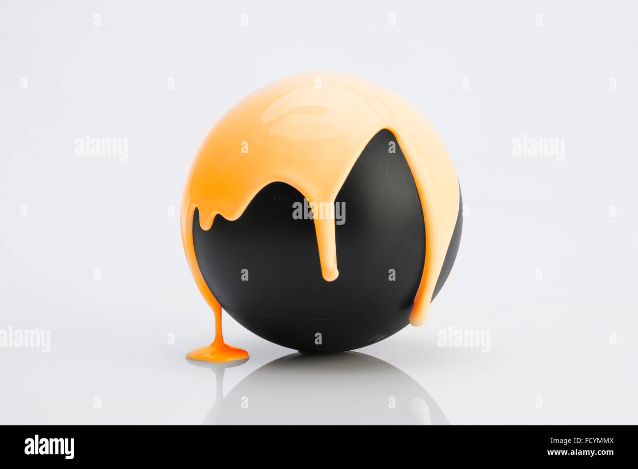 Black sphere dripping with yellow paint Stock Photo - Alamy