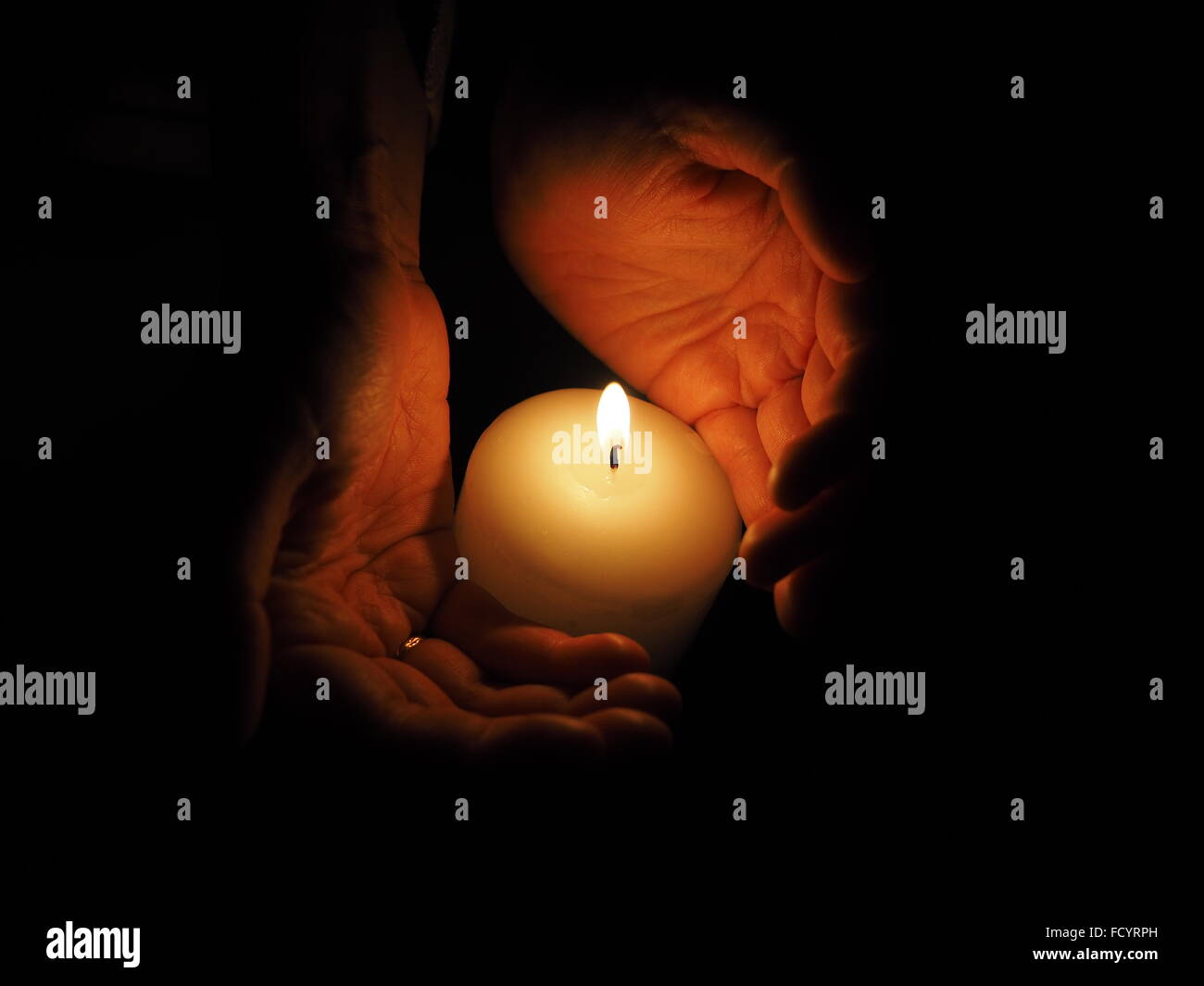 candle and hands on a black background Stock Photo - Alamy